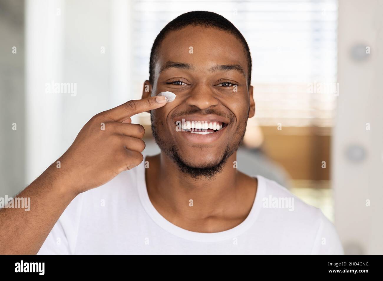 Closeup Shot Of Smiling Handsome Black Man Applying Moisturising Cream ...
