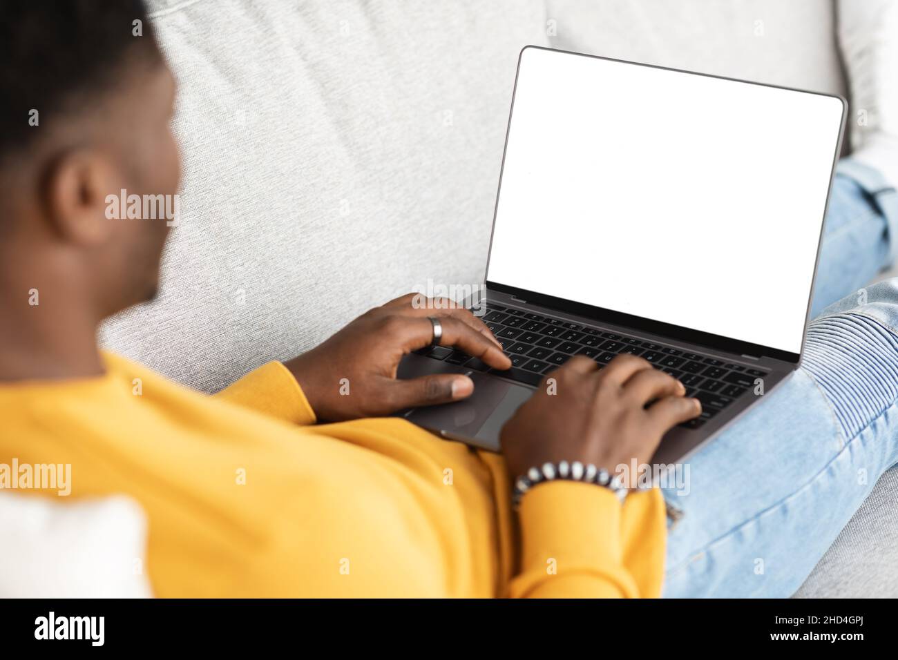 Unrecognizable black guy using laptop with empty screen Stock Photo - Alamy
