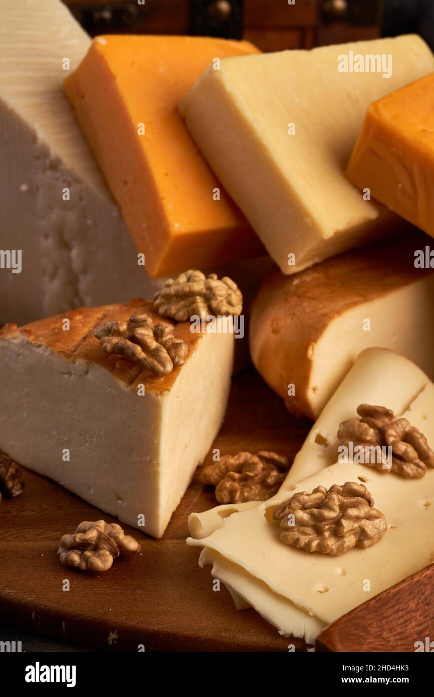 Variety of mature and creamy cheeses on a vintage wooden board Stock ...