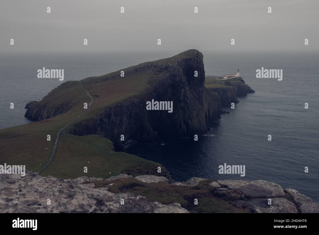 Neist Point Lighthouse during a foggy, cold and wet sunset on Isle of ...