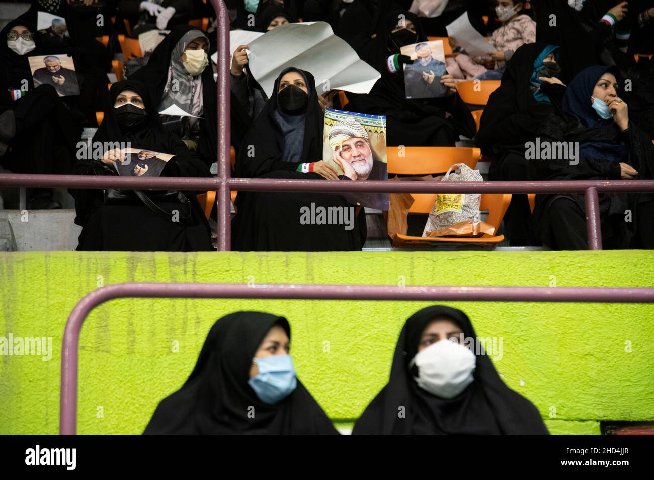 A woman holds posters of the Iranian former Islamic Revolutionary Guard ...