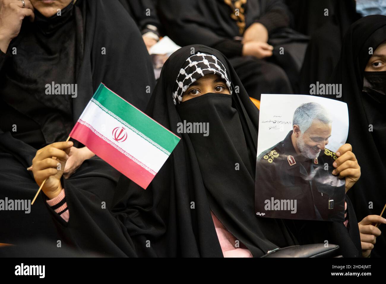 A woman holds posters of the Iranian former Islamic Revolutionary Guard ...