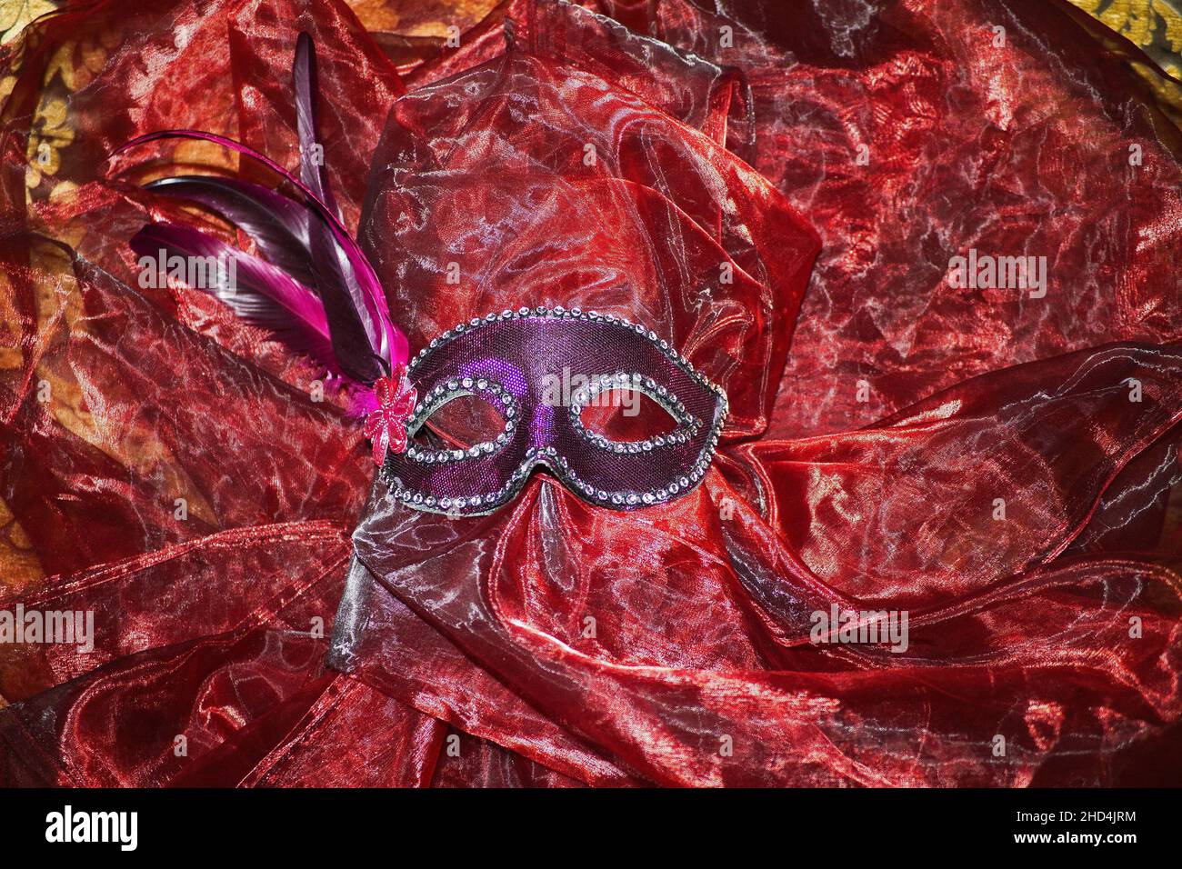 purple carnival mask on bright red cloth Stock Photo - Alamy