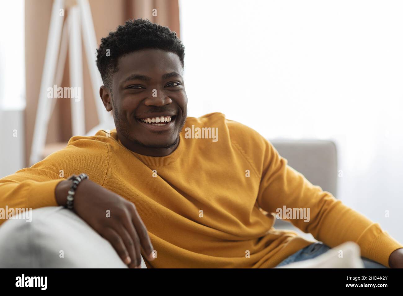 Portrait of happy black guy posing at home Stock Photo - Alamy