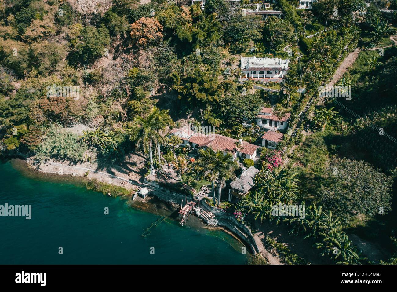 Aerial view of trees and buildings on the coast of Lake Atitlan in ...