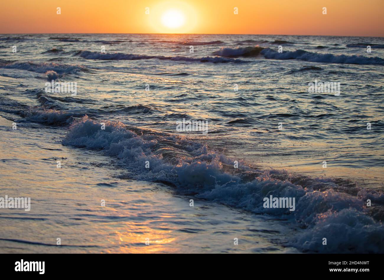 Beautiful sunset over the sea. Red sun and waves Stock Photo - Alamy
