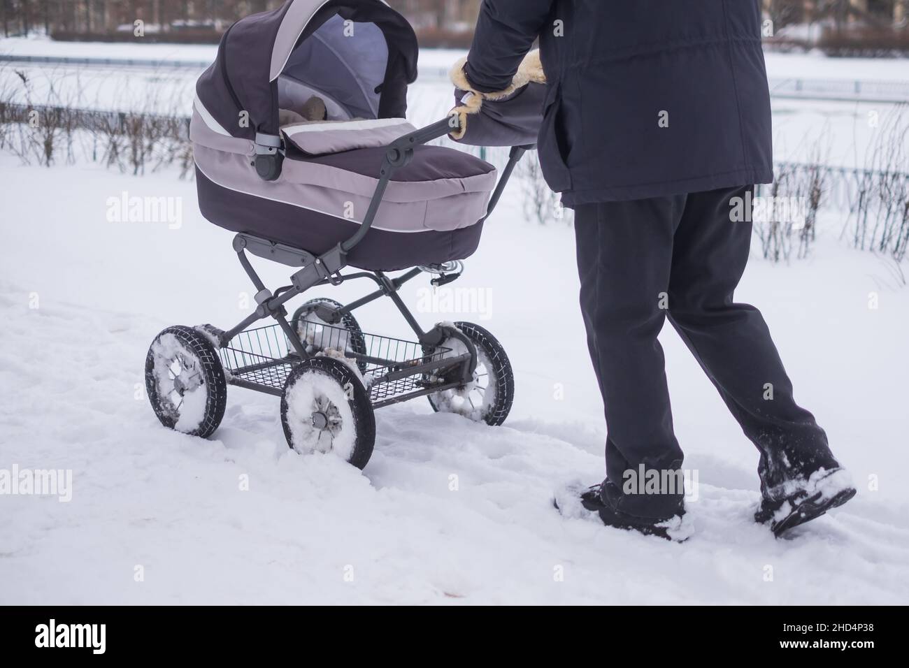 Baby stroller wheel on snowy road in winter Stock Photo - Alamy