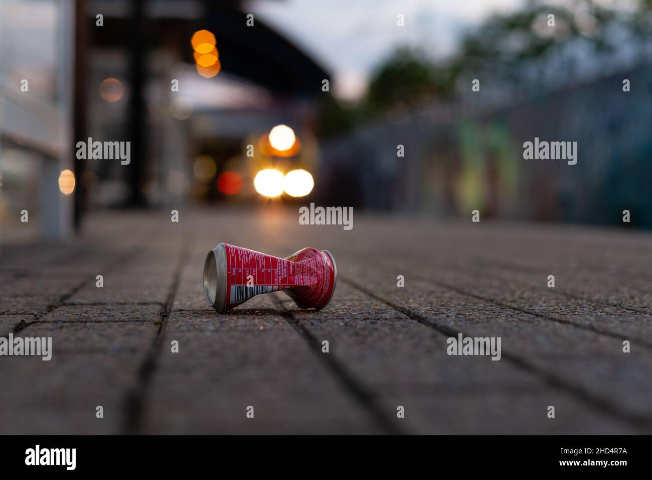 Low angle of a soda can dropped on the ground with the blurry ...