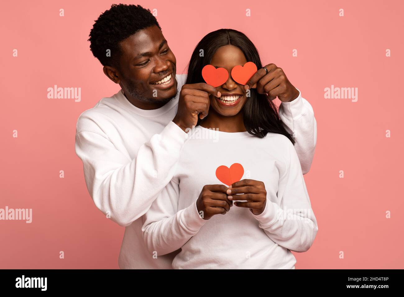 Loving black guy covering his girlfriend eyes with Valentine cards Stock Photo - Alamy