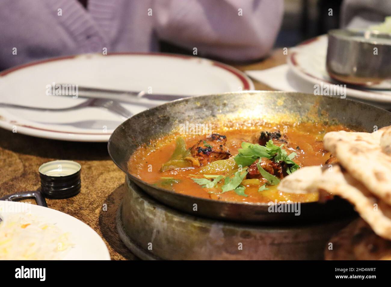 A metal bowl of chicken curry in a Punjabi restaurant Stock Photo - Alamy