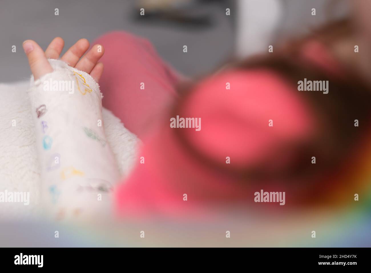 Girl's broken left arm has drawn a cute image on her arm on the plaster ...