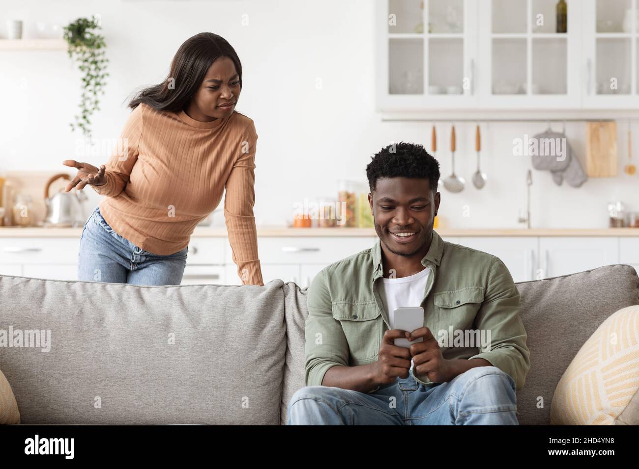 Furious black wife scolding her husband chatting with ladies Stock ...