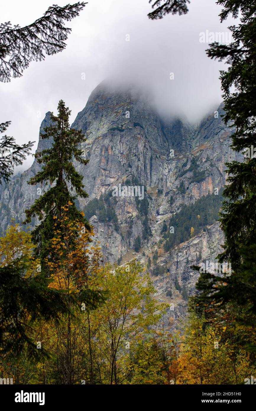 Beautiful shot of an old gray rocky mountain with a gray foggy sky and ...