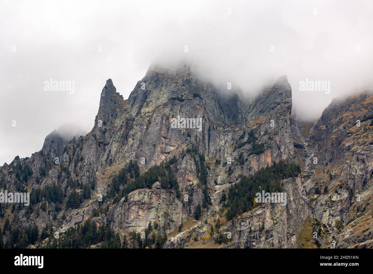 Beautiful shot of an old gray rocky mountain with a gray foggy sky ...