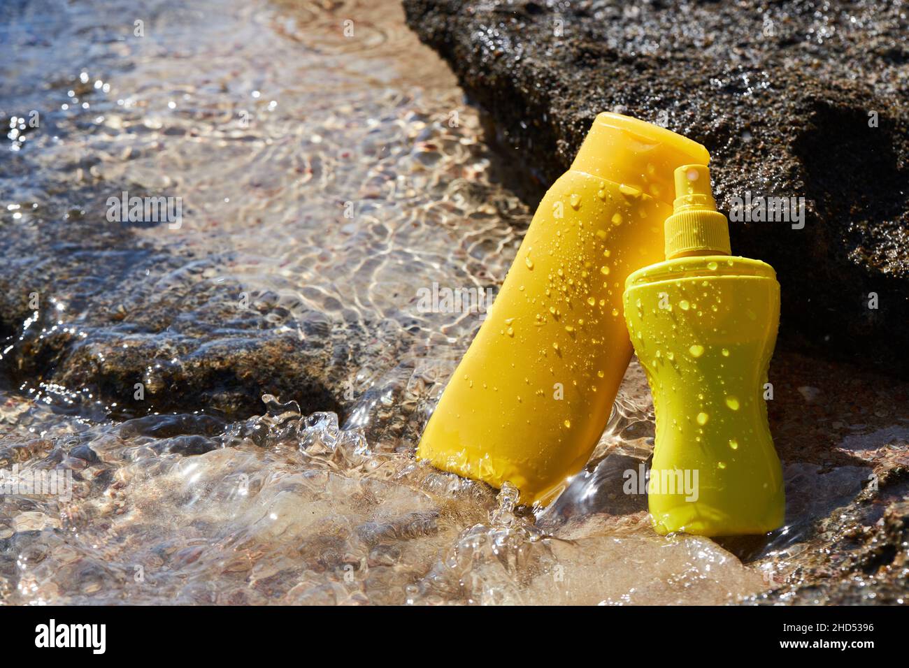 Yellow sunscreen cream bottles for skin protection on a stone in the ...
