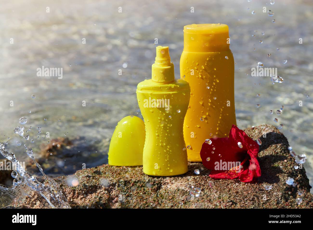 Yellow sunscreen cream bottles for skin protection with a red Hibiscus ...