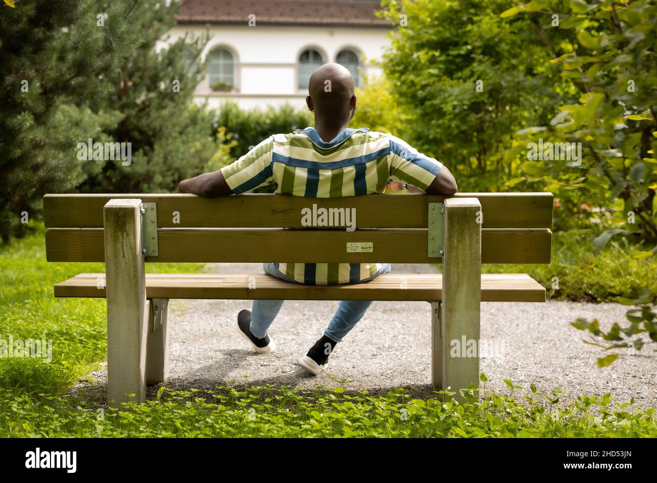 Lonely man sitting on the bench and watching the park scene Stock Photo ...