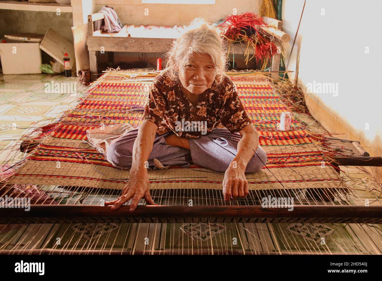 Old woman weaving a traditional sedge mats in Duy Vinh Village, Vietnam ...