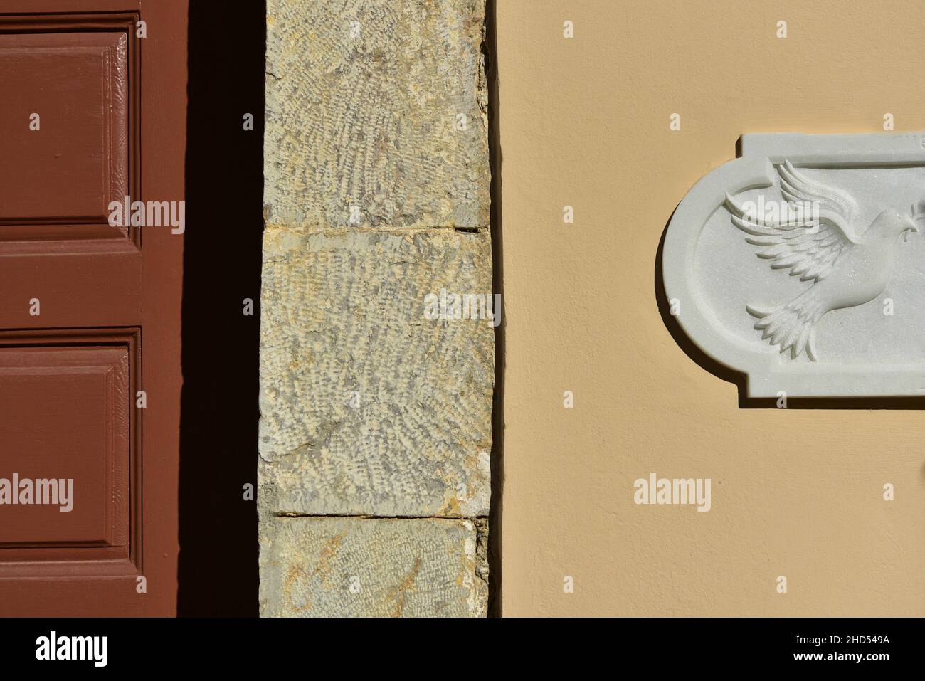 Neoclassical house facade with a wooden door, stone trim and a handmade ...