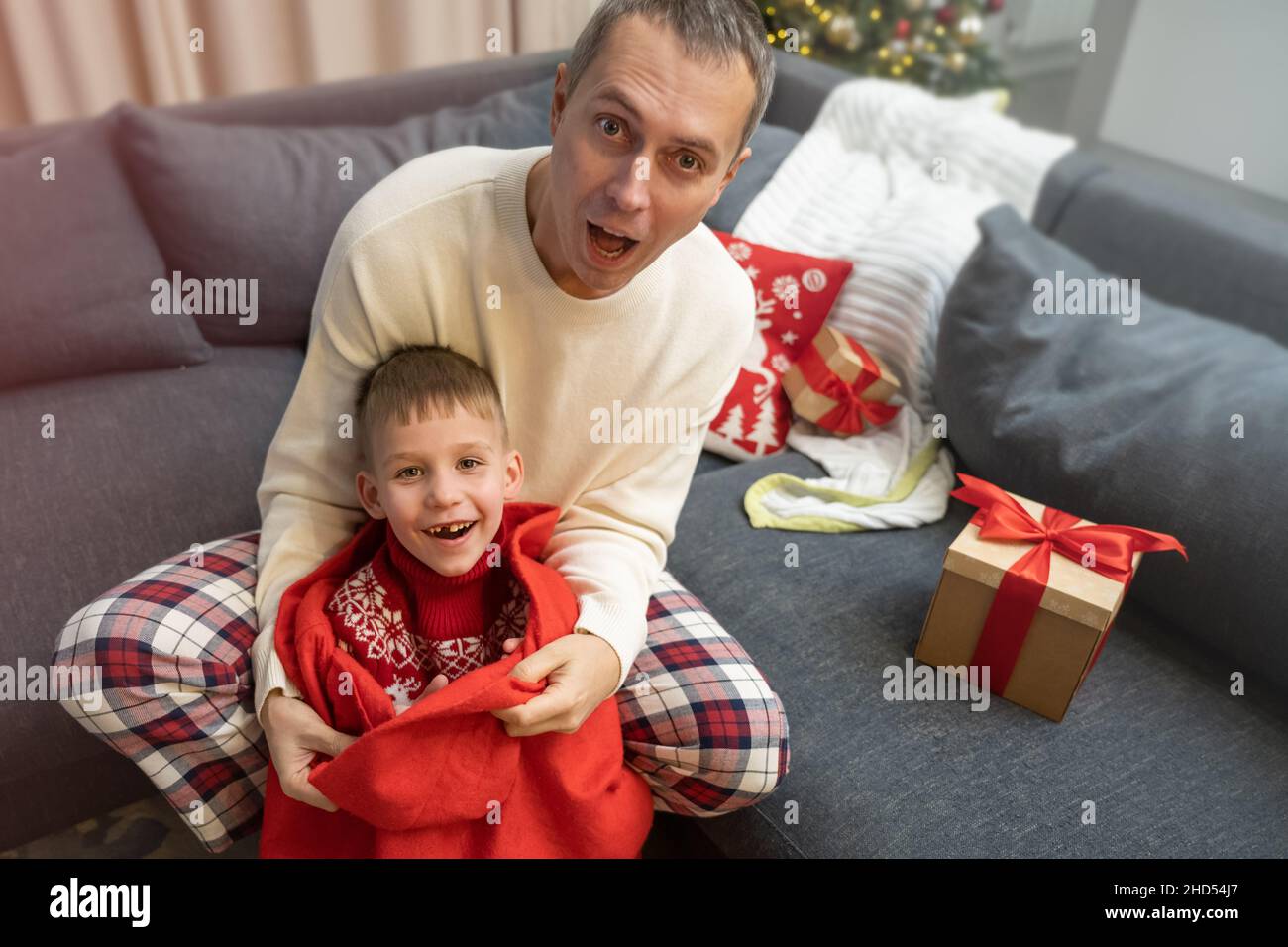 dad and son play and laugh with santa bag Stock Photo - Alamy