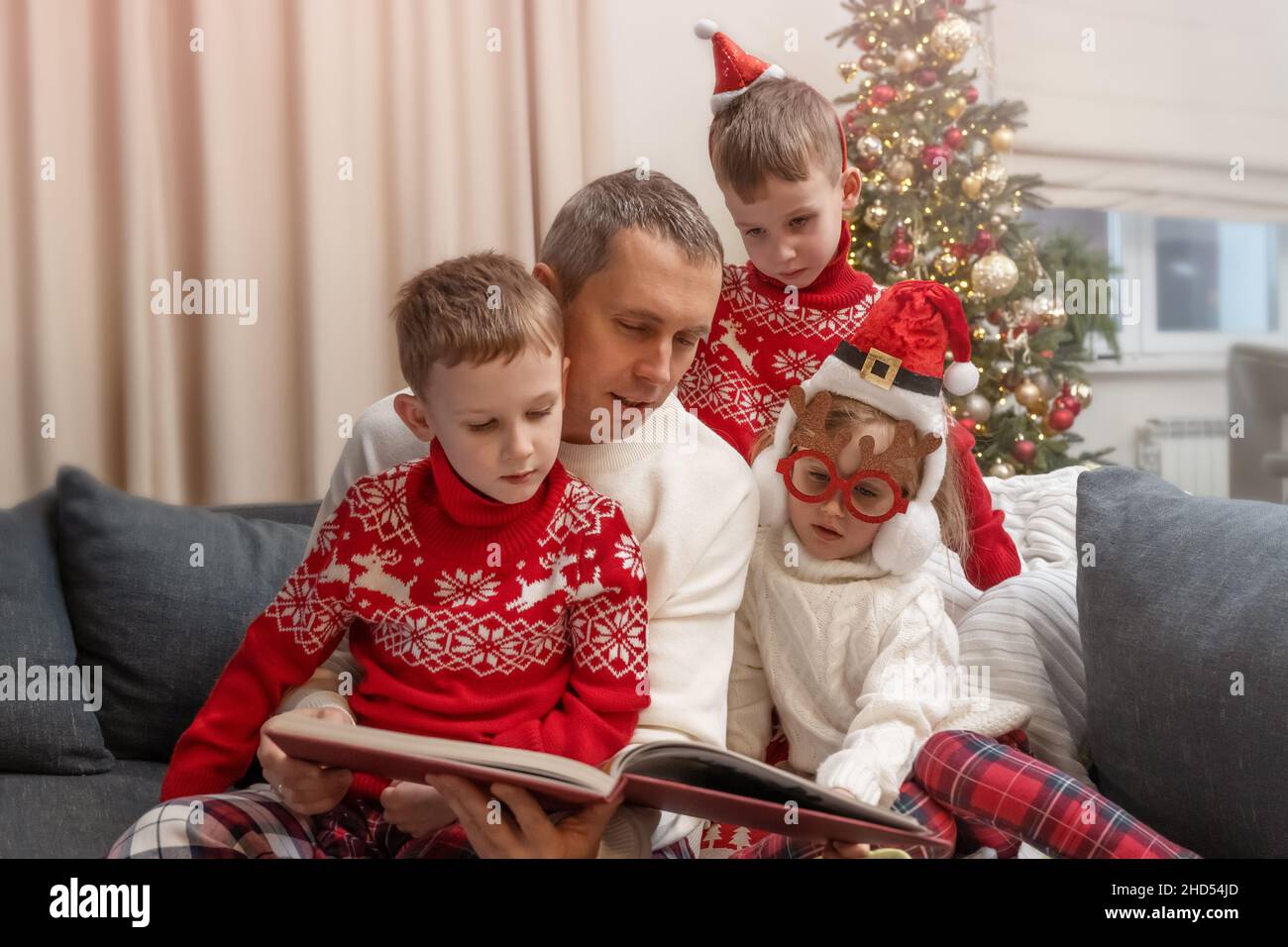 dad reads a christmas tale to children Stock Photo - Alamy