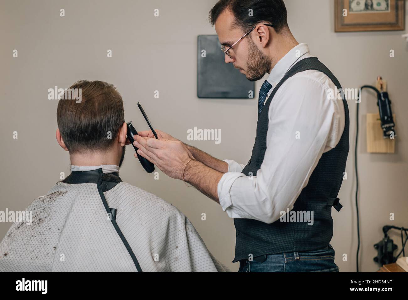 Hairdresser barber cuts hair with trimer Stock Photo - Alamy