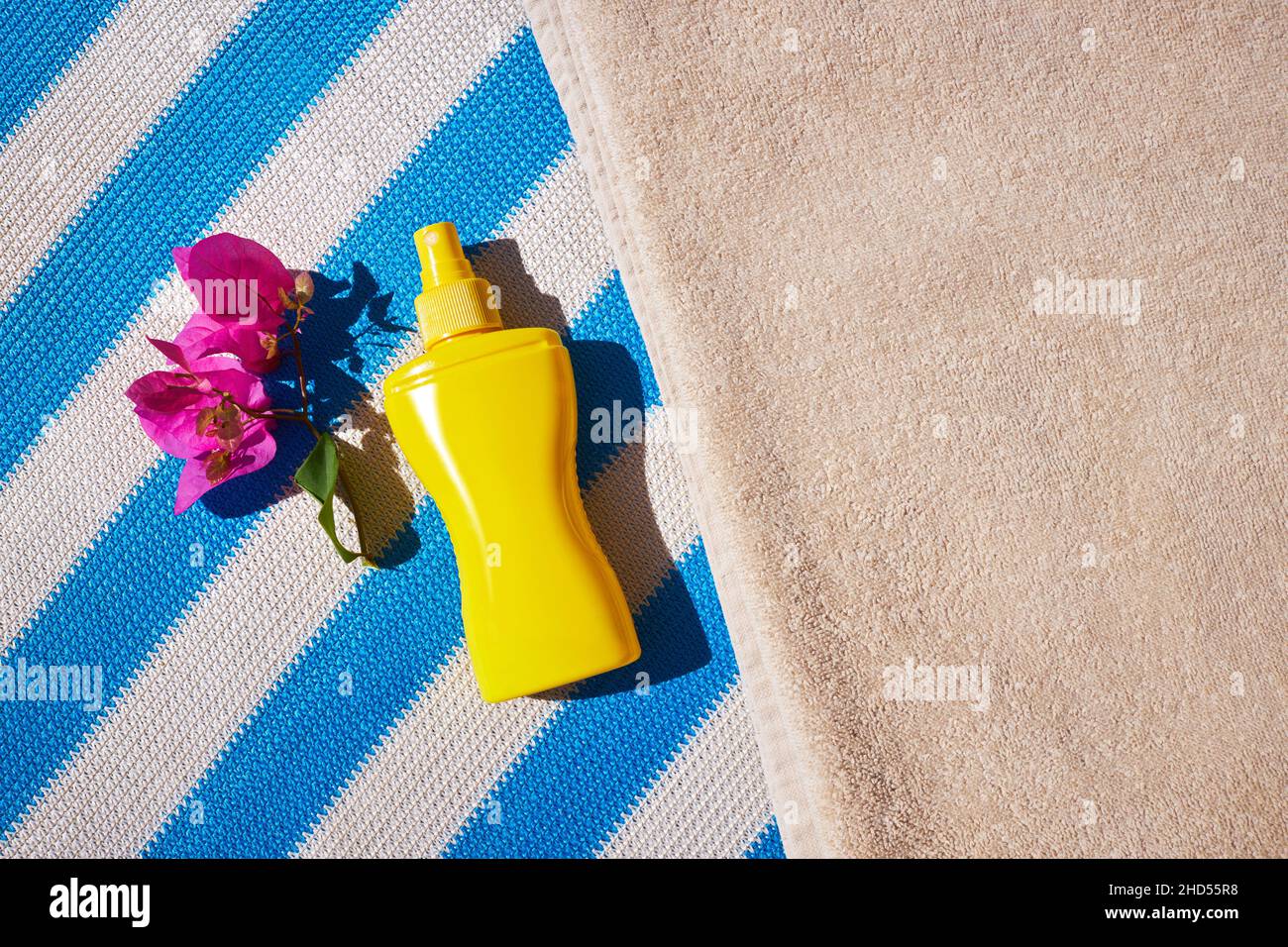 Yellow sunscreen cream bottle for skin protection, beach towel and ...