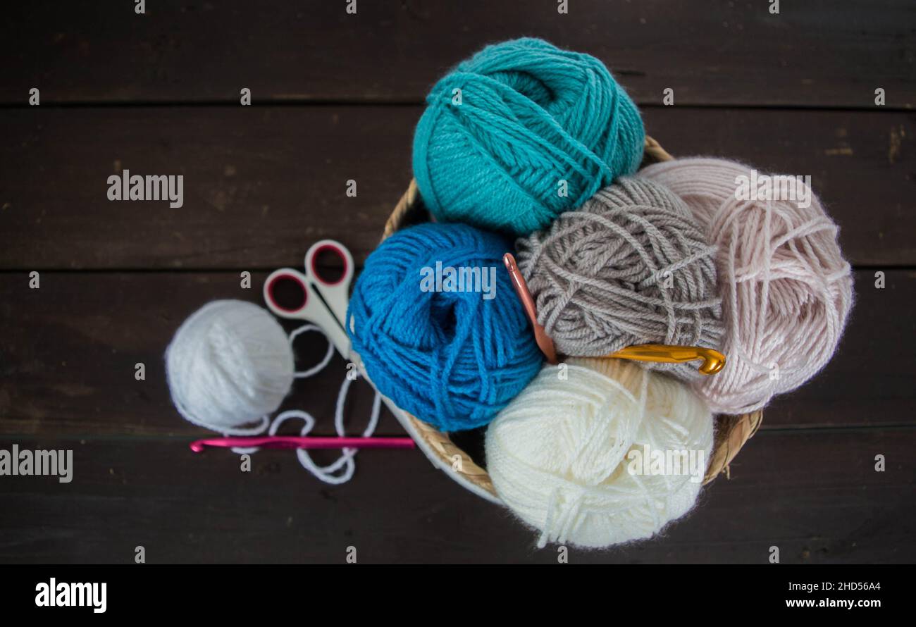 colorful woolen balls on dark brown wooden ground for handicrafts ...