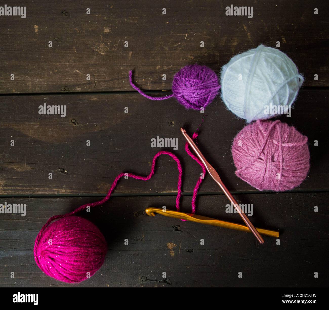 colorful woolen balls on dark brown wooden ground for handicrafts ...