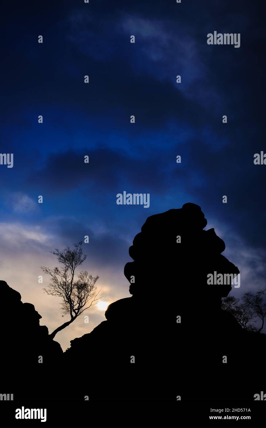 Millstone grit weathered gritstone formation silhouetted against the ...
