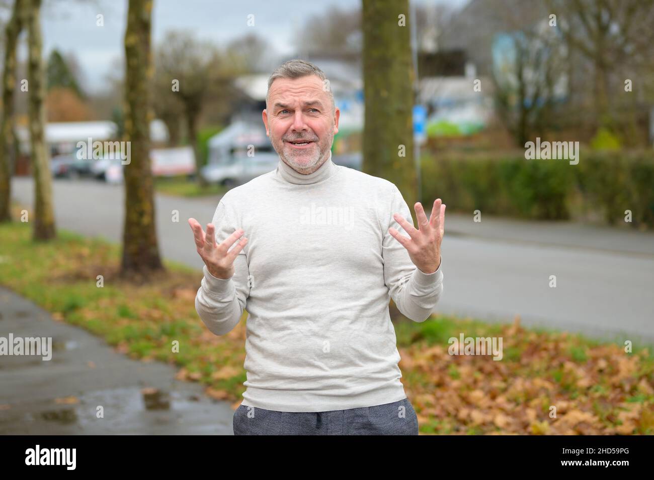 Upset or exasperated man gesturing with his fingers as he looks at the ...