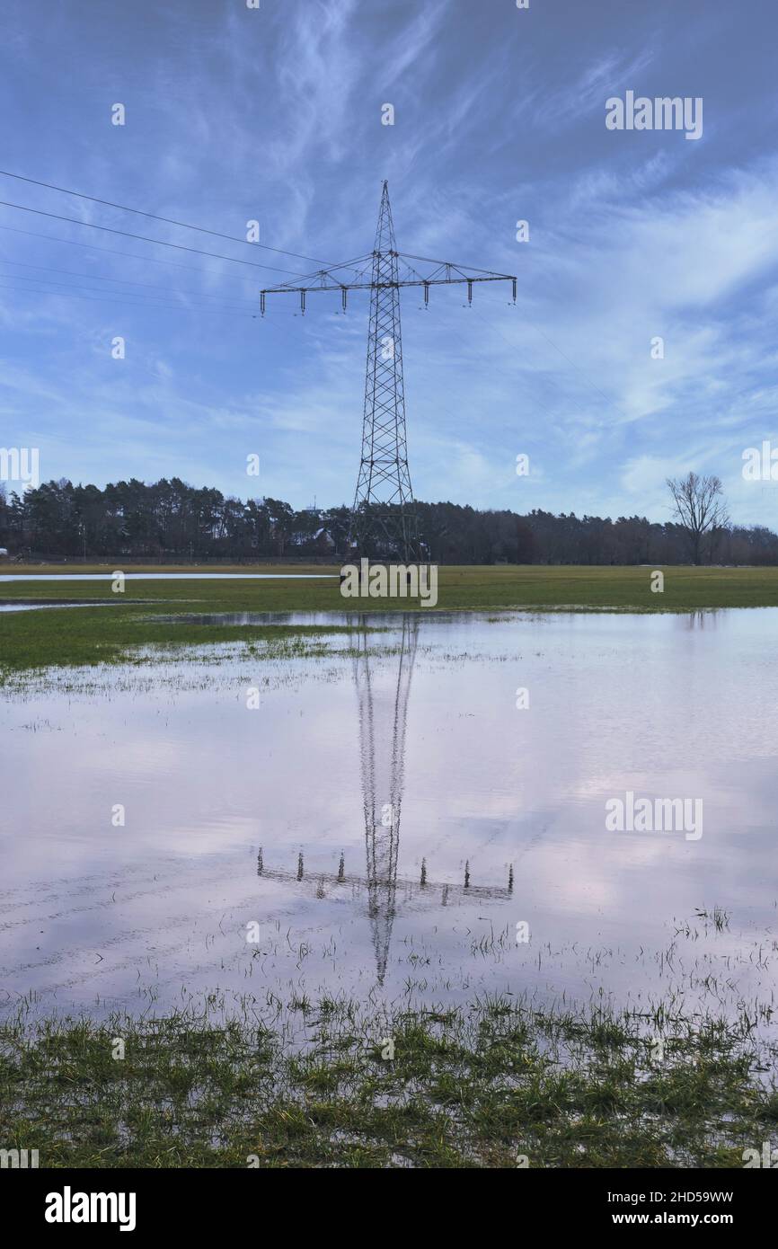 Tranquil scenery of an electrical tower reflecting on the pond in the ...