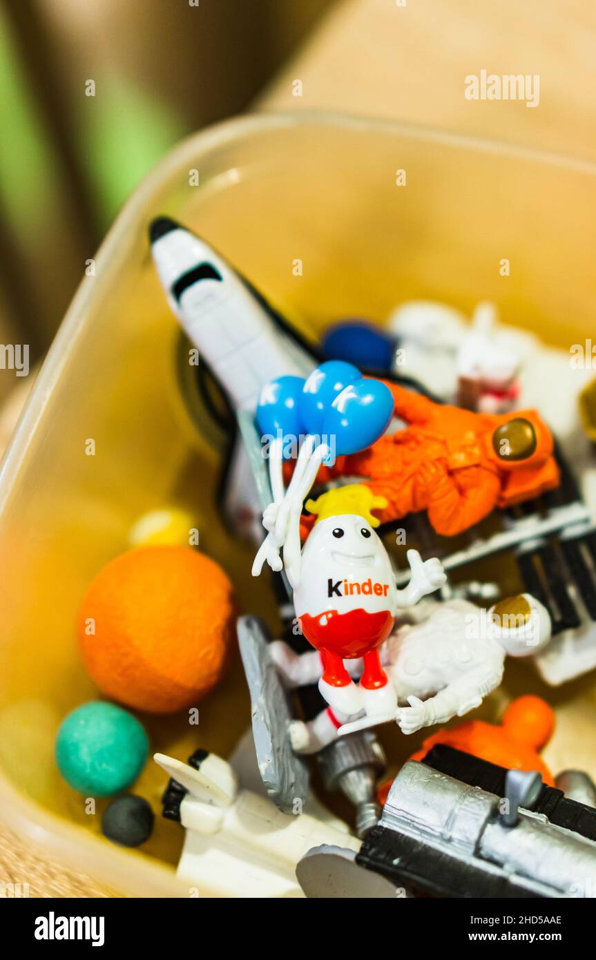 Mix of toys in a plastic container including a Kinder egg figurine ...