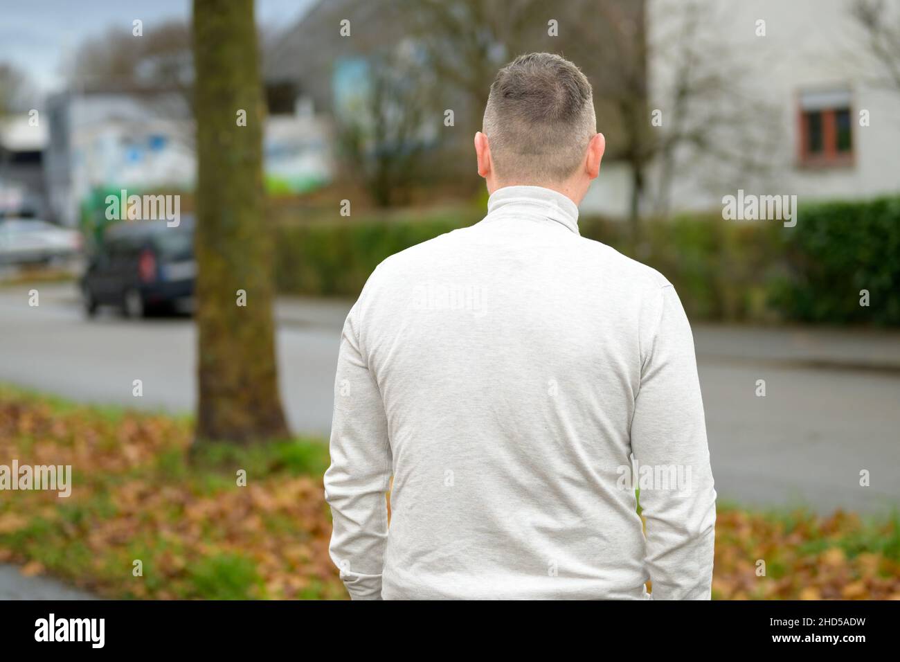 Back view of a middle-aged man posing in an urban street in winter ...