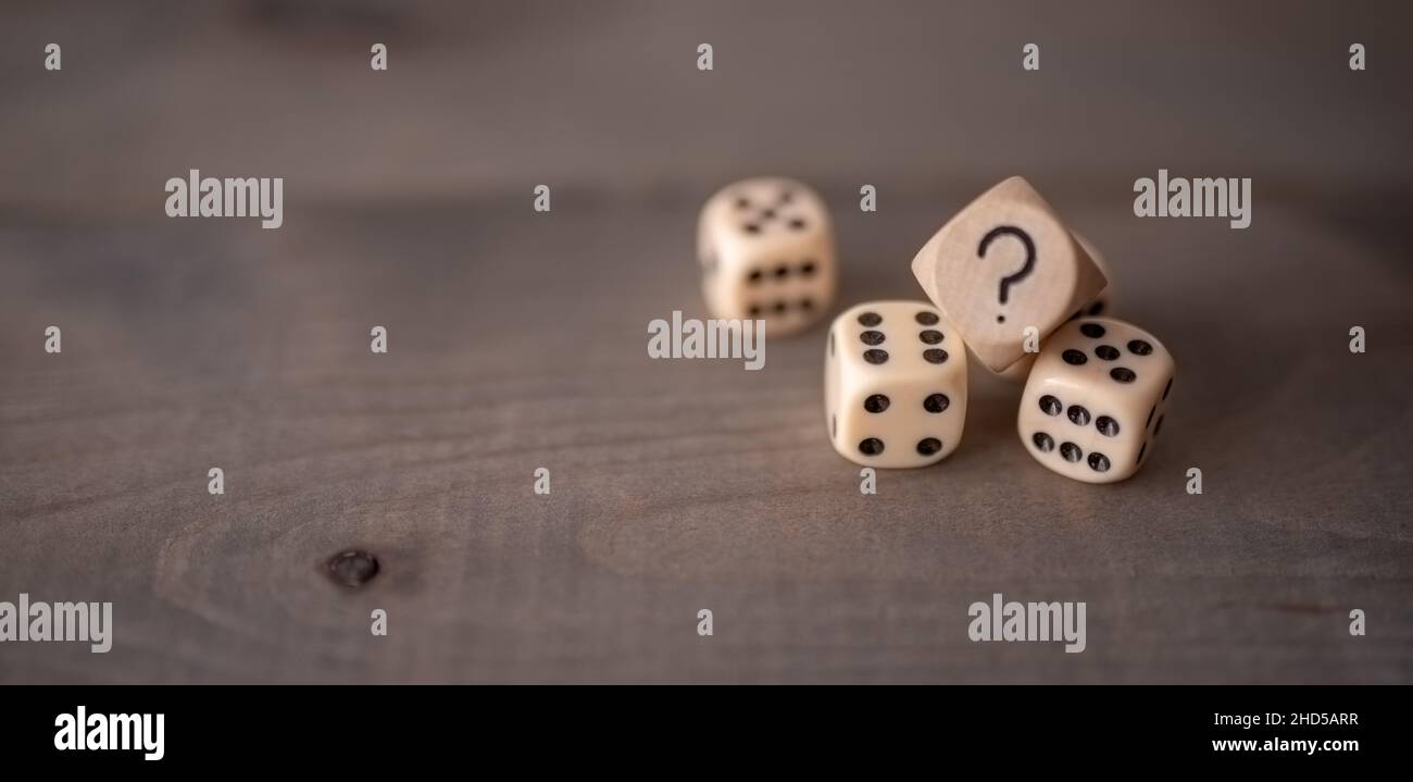 game dice, question mark on wooden background. Concept photo with copy ...