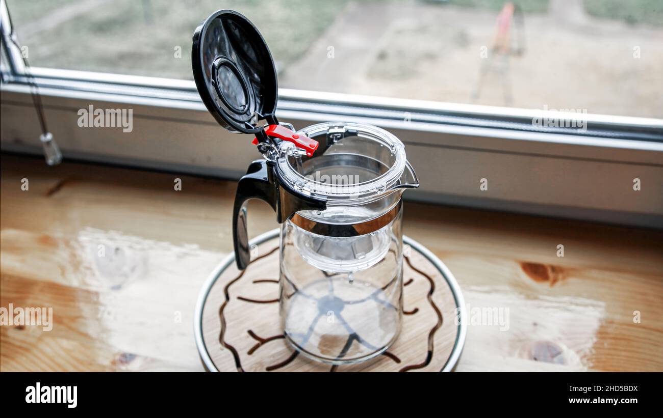 Plastic-glass teapot with button and tea brewing flask with open lid ...