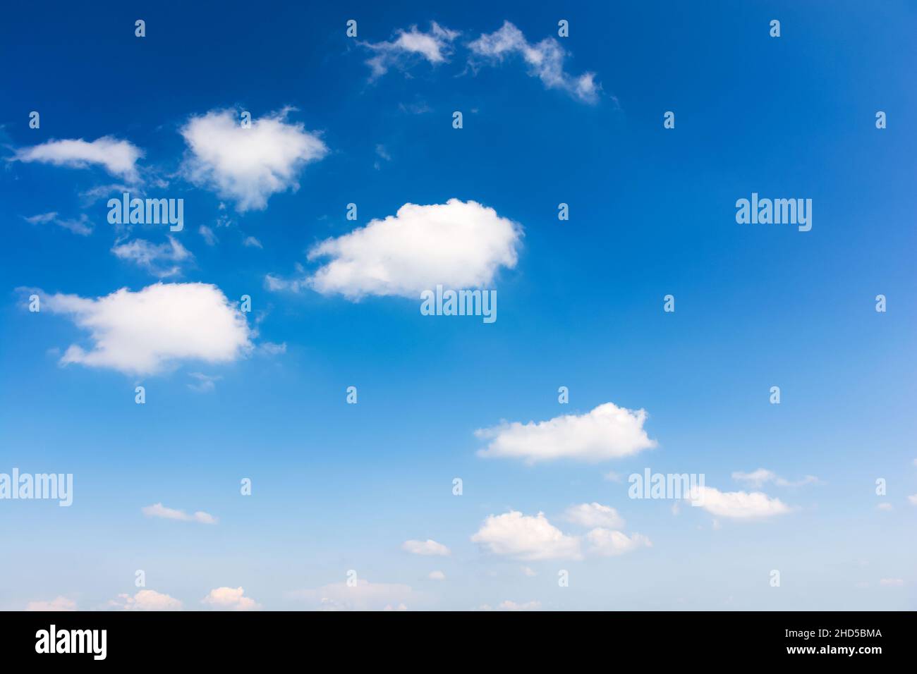 sky with fluffy clouds. white cumulus sparse cloudscape on a deep blue ...