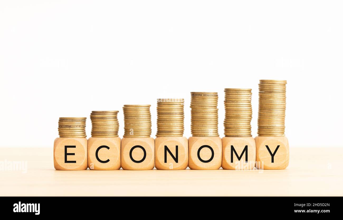Economy concept. Wooden blocks with text and rising stacked coins. Copy ...
