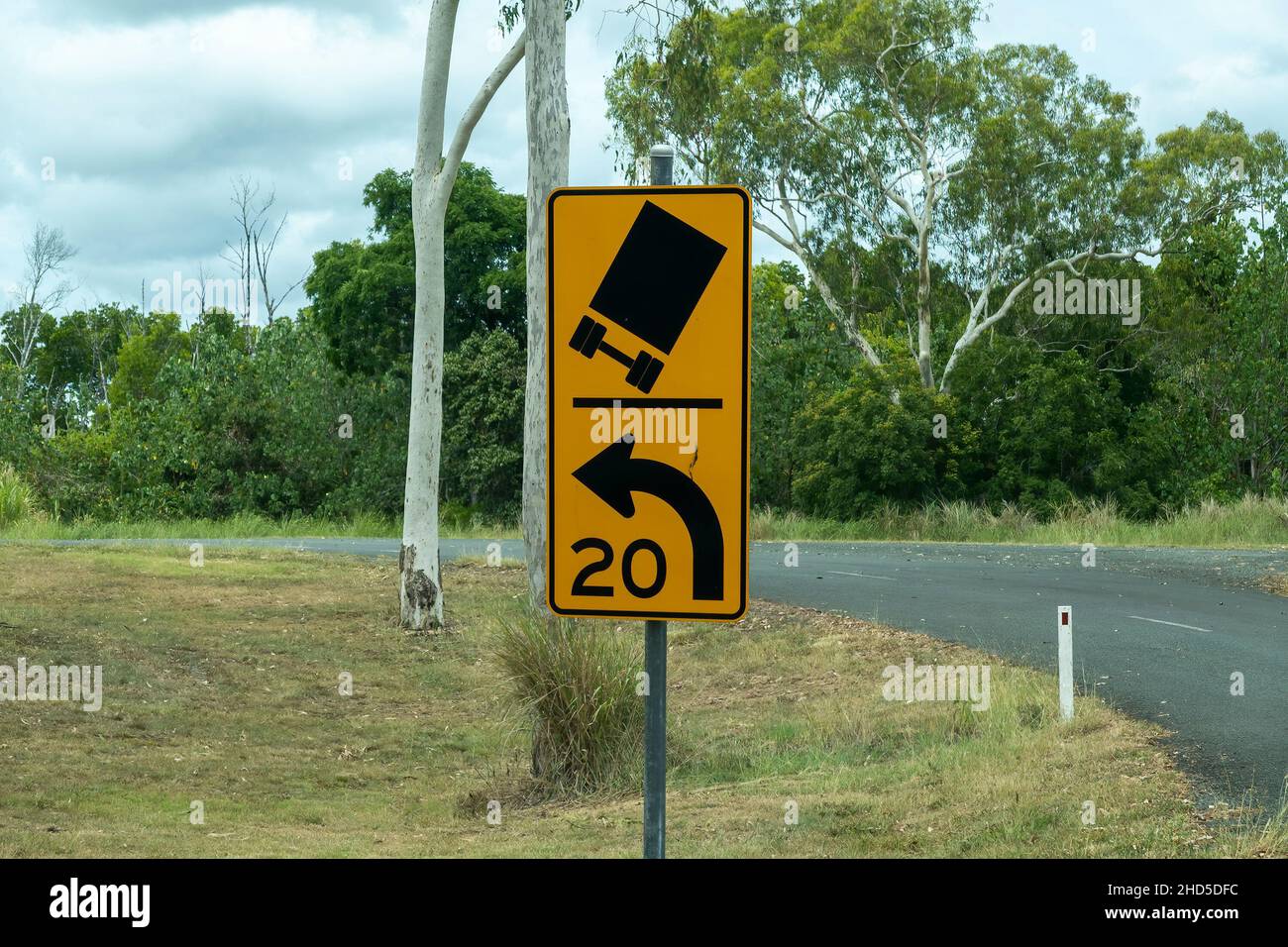 Warning road sign of sharp bend in country road Stock Photo - Alamy