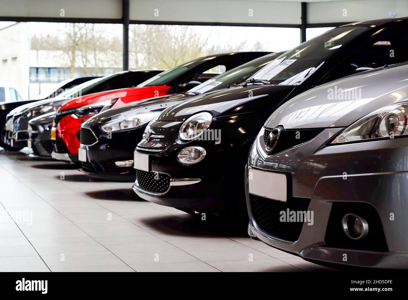 Various brands and types of cars prepared for sale in a showroom Stock ...