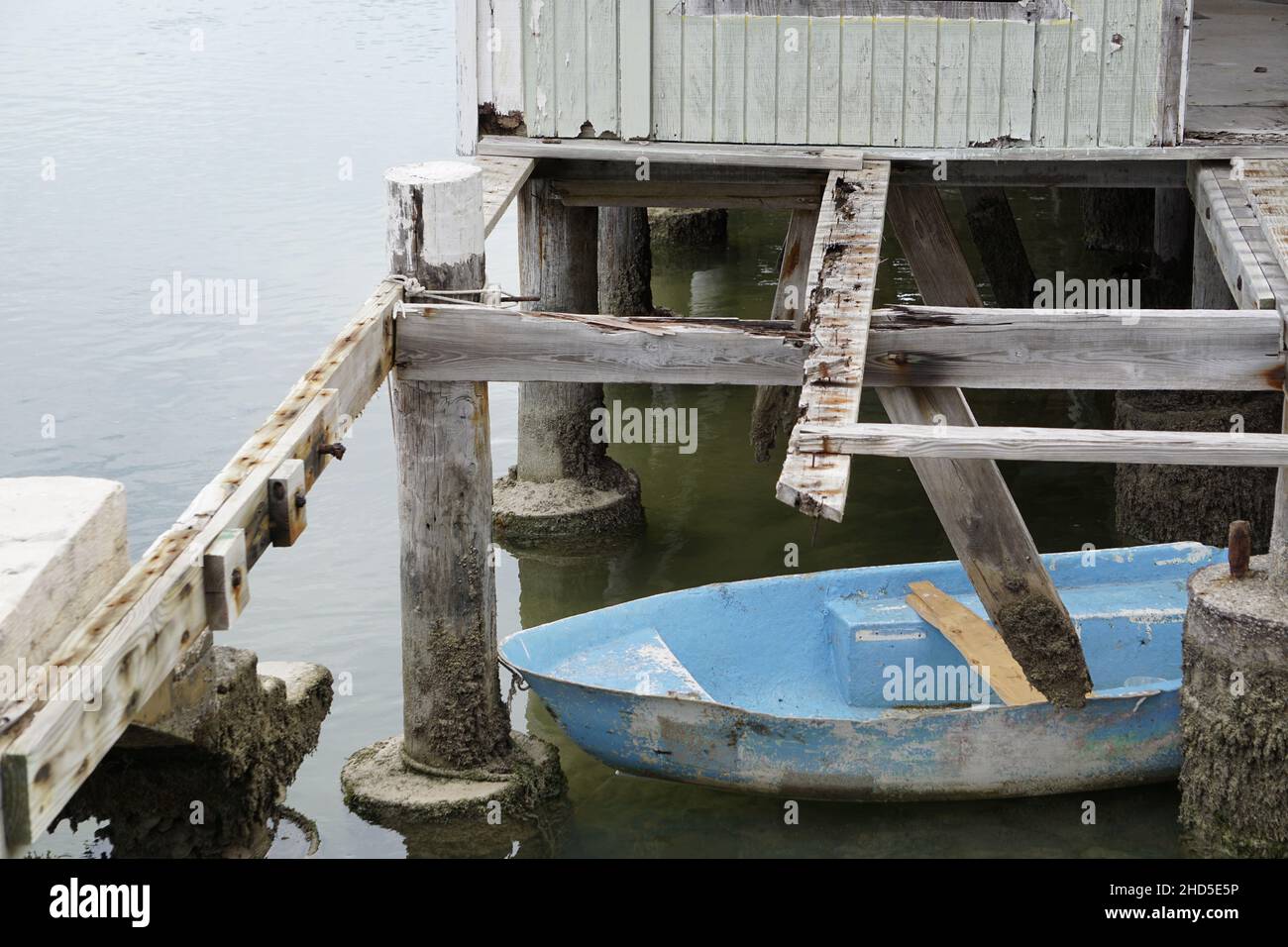 Old boat in water under a wooden construction Stock Photo - Alamy