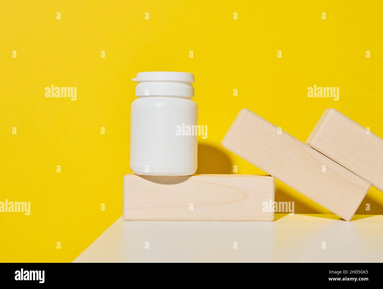 white plastic jar for pills, cream and medicines on a yellow background ...
