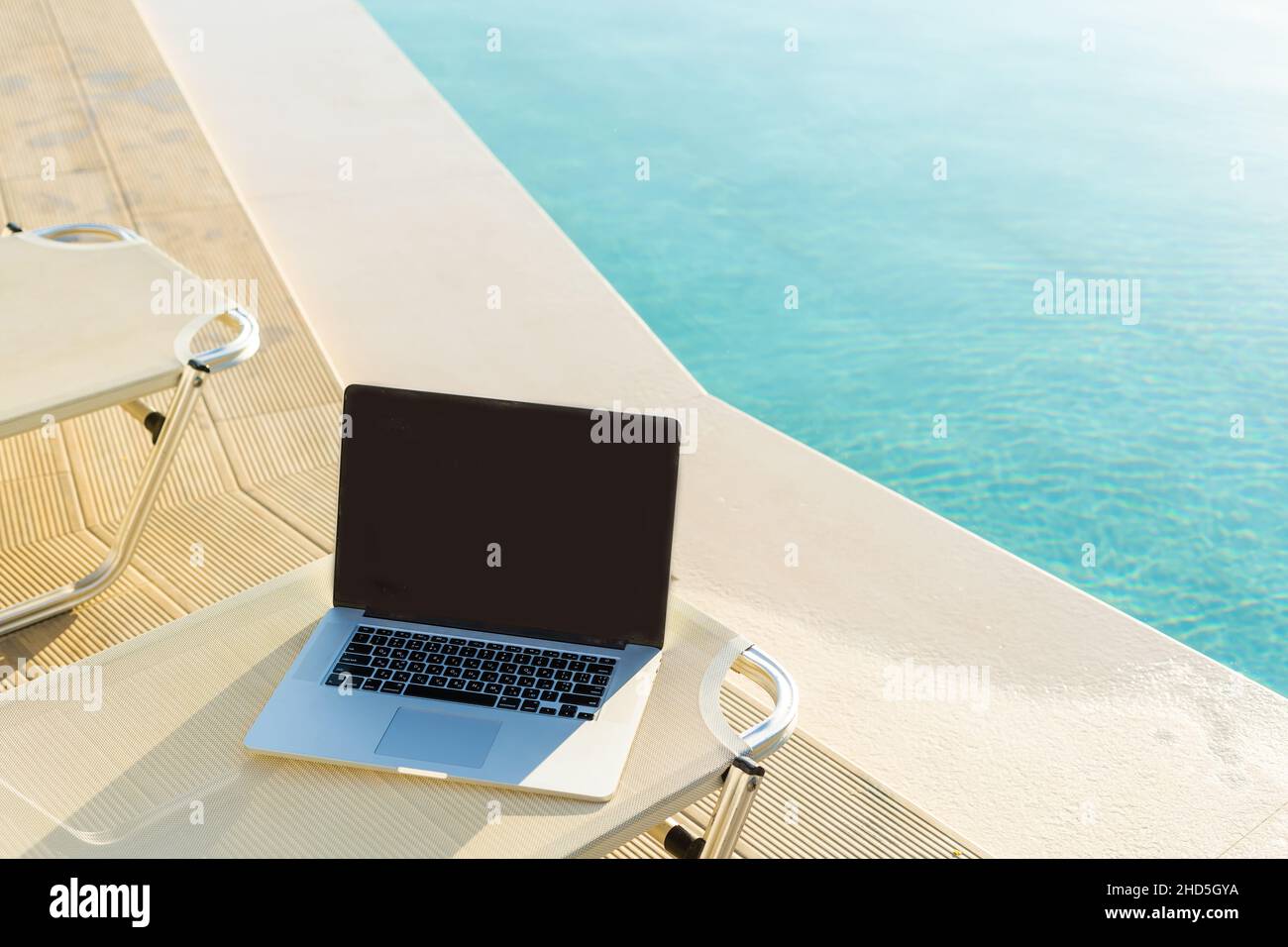 a laptop on the deckchair in swimming pool Stock Photo - Alamy