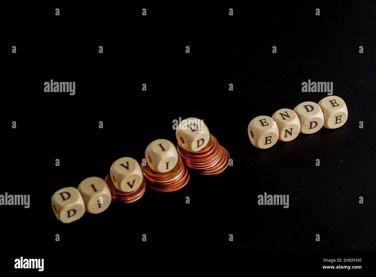 Staples of coins with wooden letters cubes forming the word "Divid Ende ...