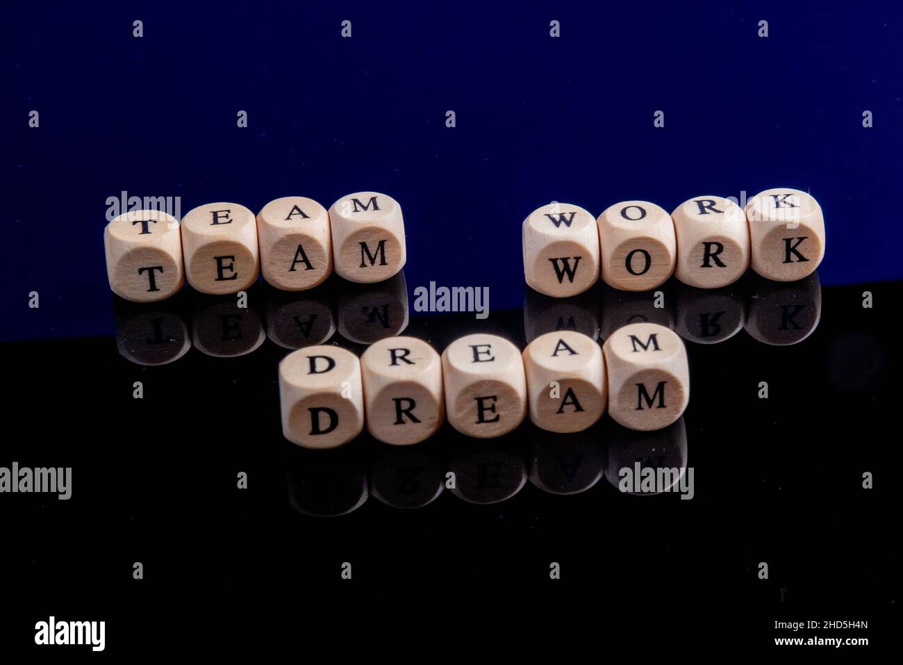 White letter cubes forming the three words Team, Work, Dream in front ...