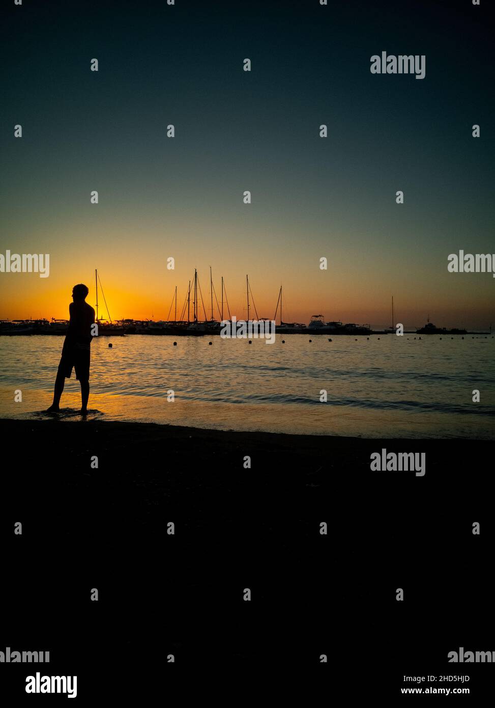 Male on a beach at scenic sunset Stock Photo - Alamy