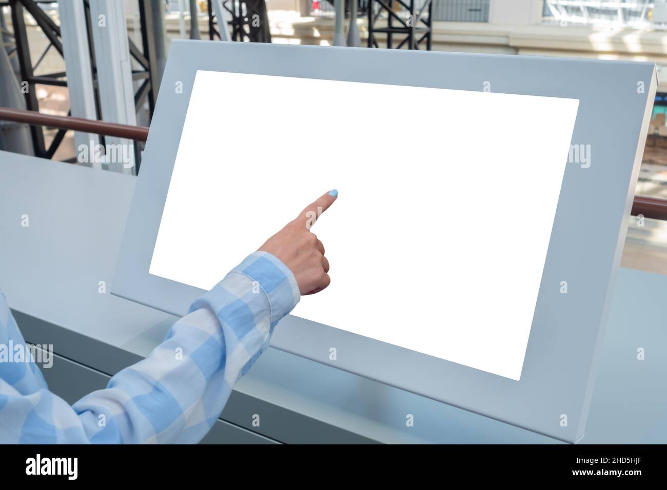 Woman hand touching interactive white touchscreen display kiosk: close ...