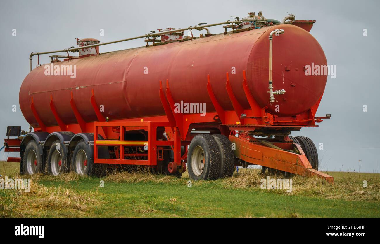 an old red lorry tanker trailer converted to a farmer's water container ...