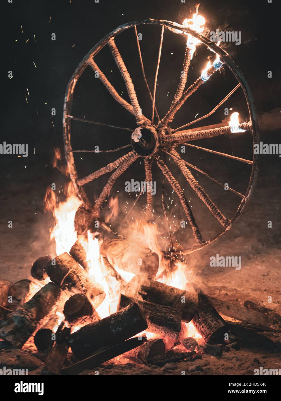 an old wheelchair burning in a fire with flames in the wheels in the ...