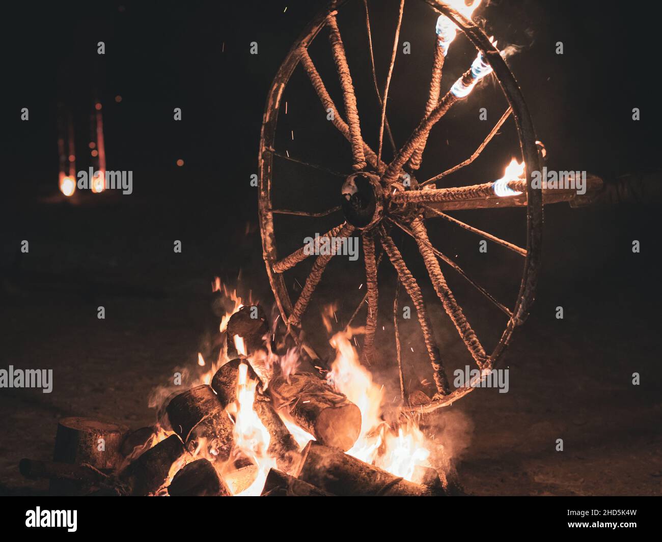 an old wheelchair burning in a fire with flames in the wheels in the ...